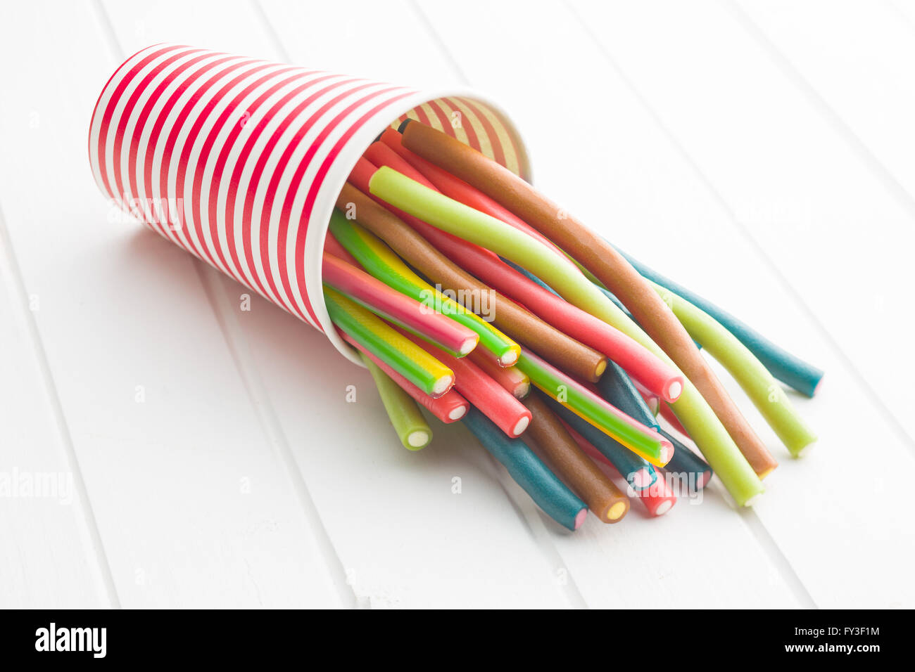 Sweet gummy sticks with different flavor. Tasty candies in paper cup ...