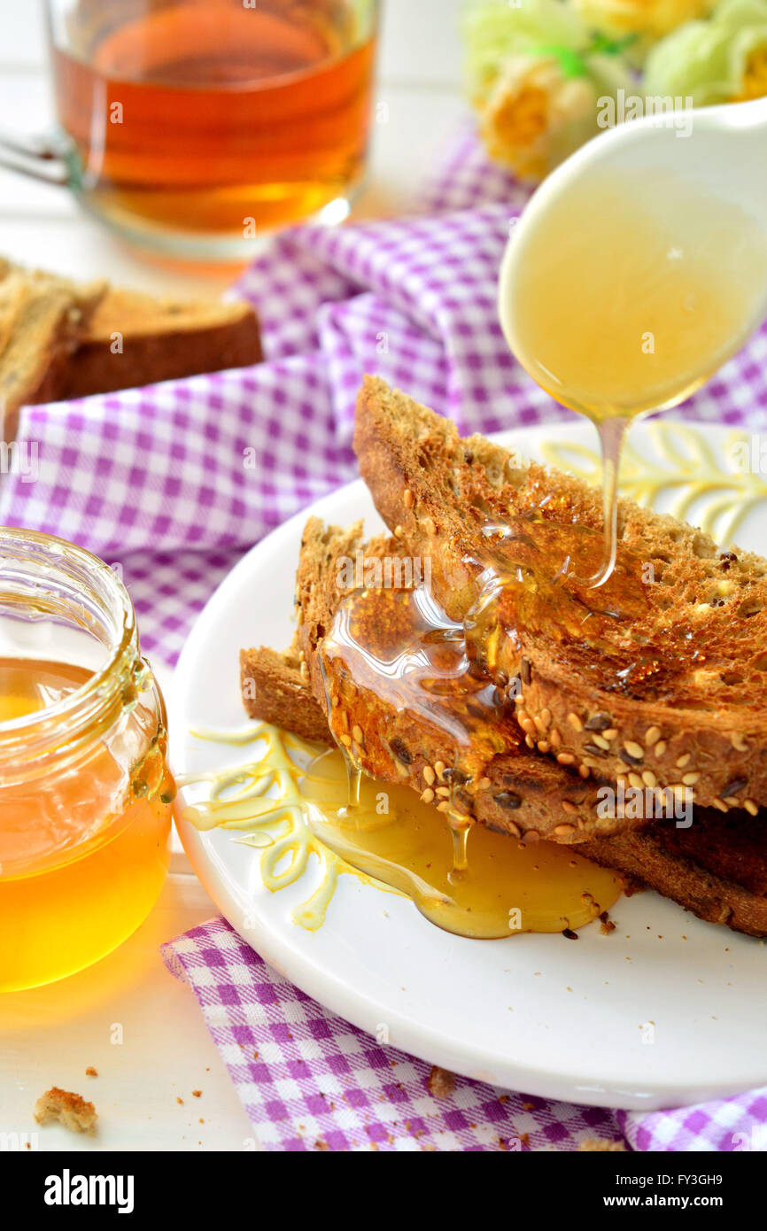 Honey poured on toast - breakfast Stock Photo - Alamy