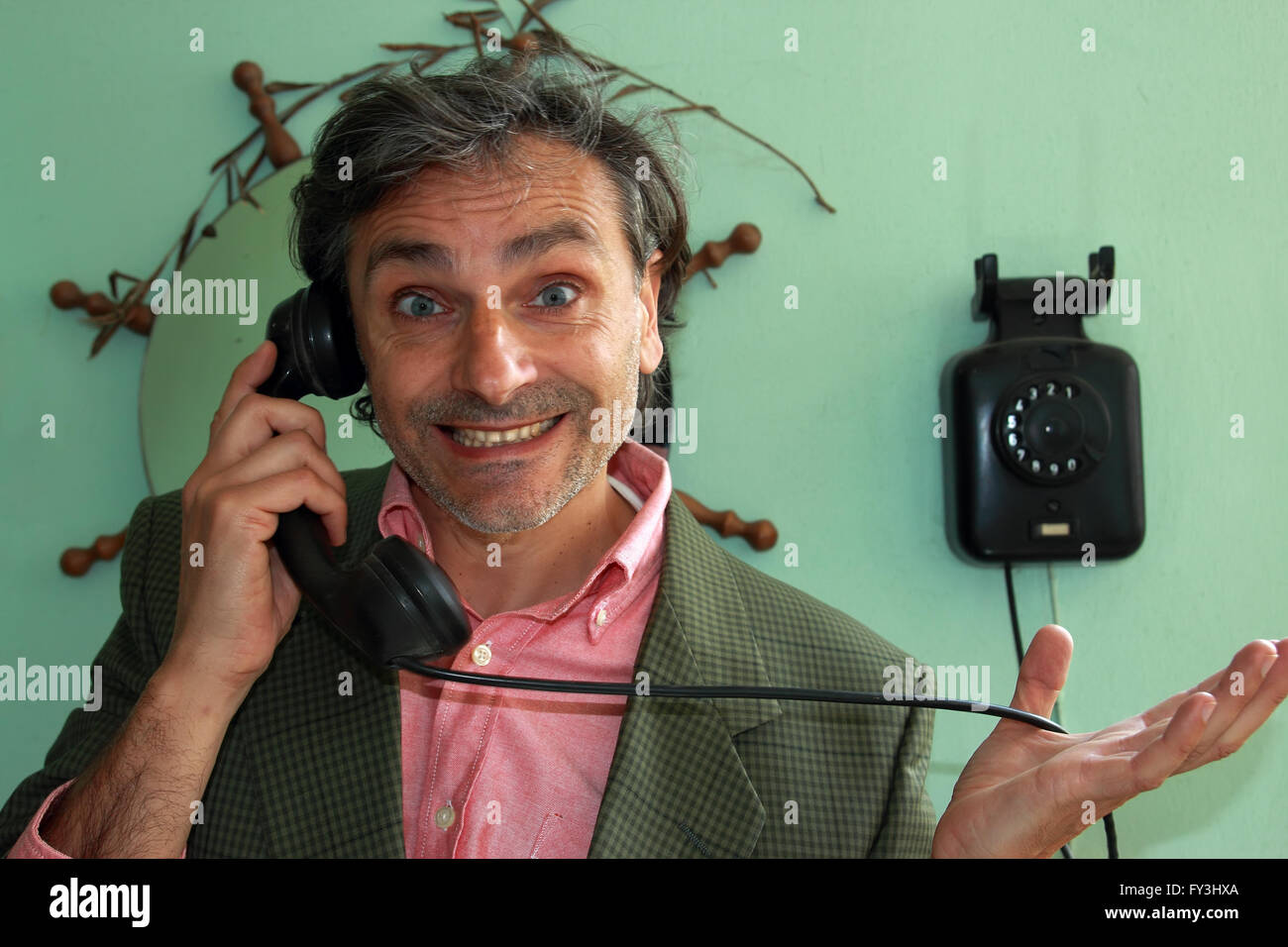 smiling man answering an old fashioned telephone Stock Photo - Alamy