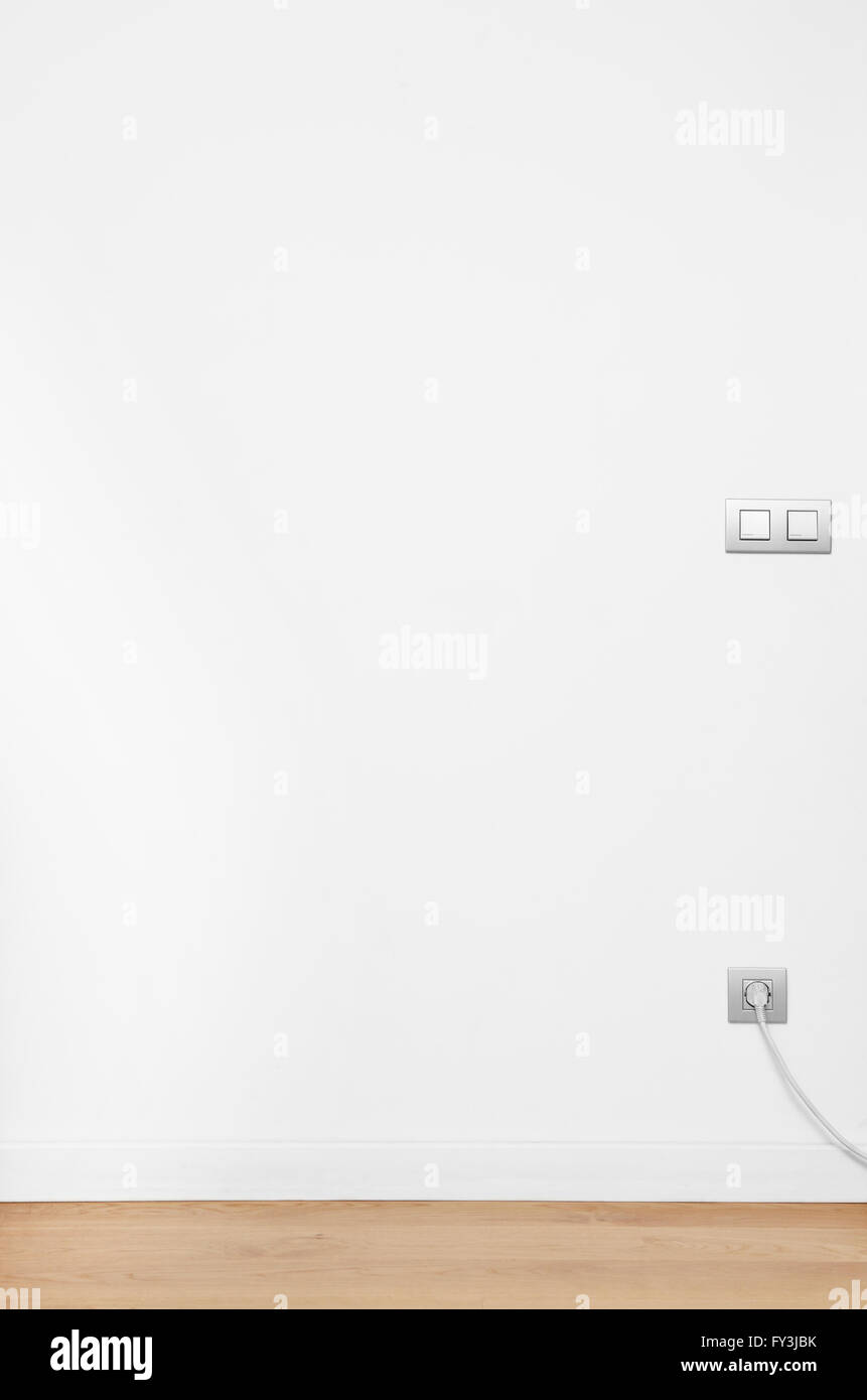 White wall with wooden floor and socket. Vertical format Stock Photo ...