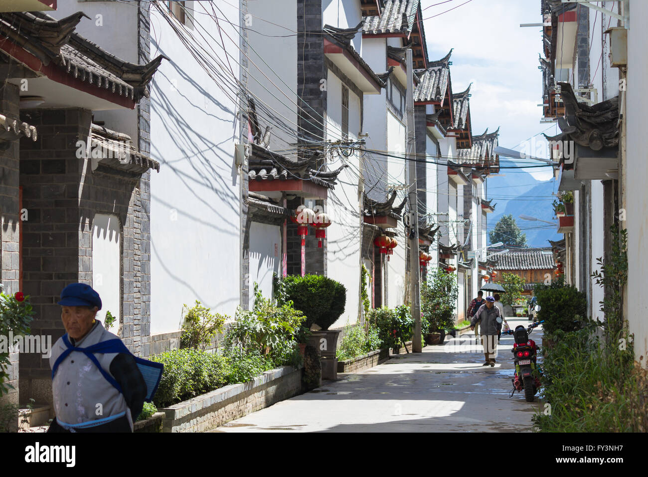 People walk through a street amidst Chinese traditional architecture in ...