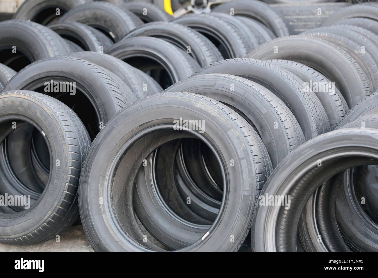 Pile of used rubber tyres in the garage shop Stock Photo - Alamy