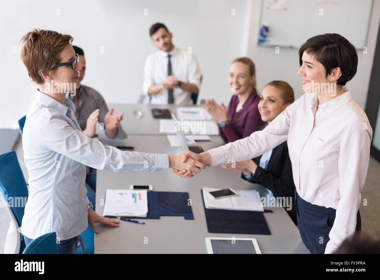 businesswomans handshake on team meeting with group of people blured in ...