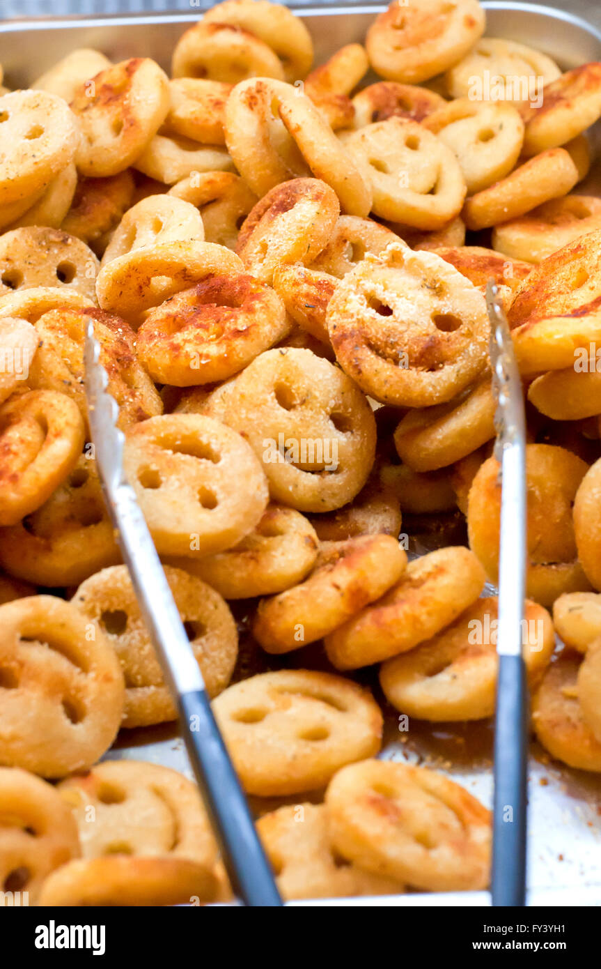 Potato fried smileys on distribution lines buffet Stock Photo - Alamy