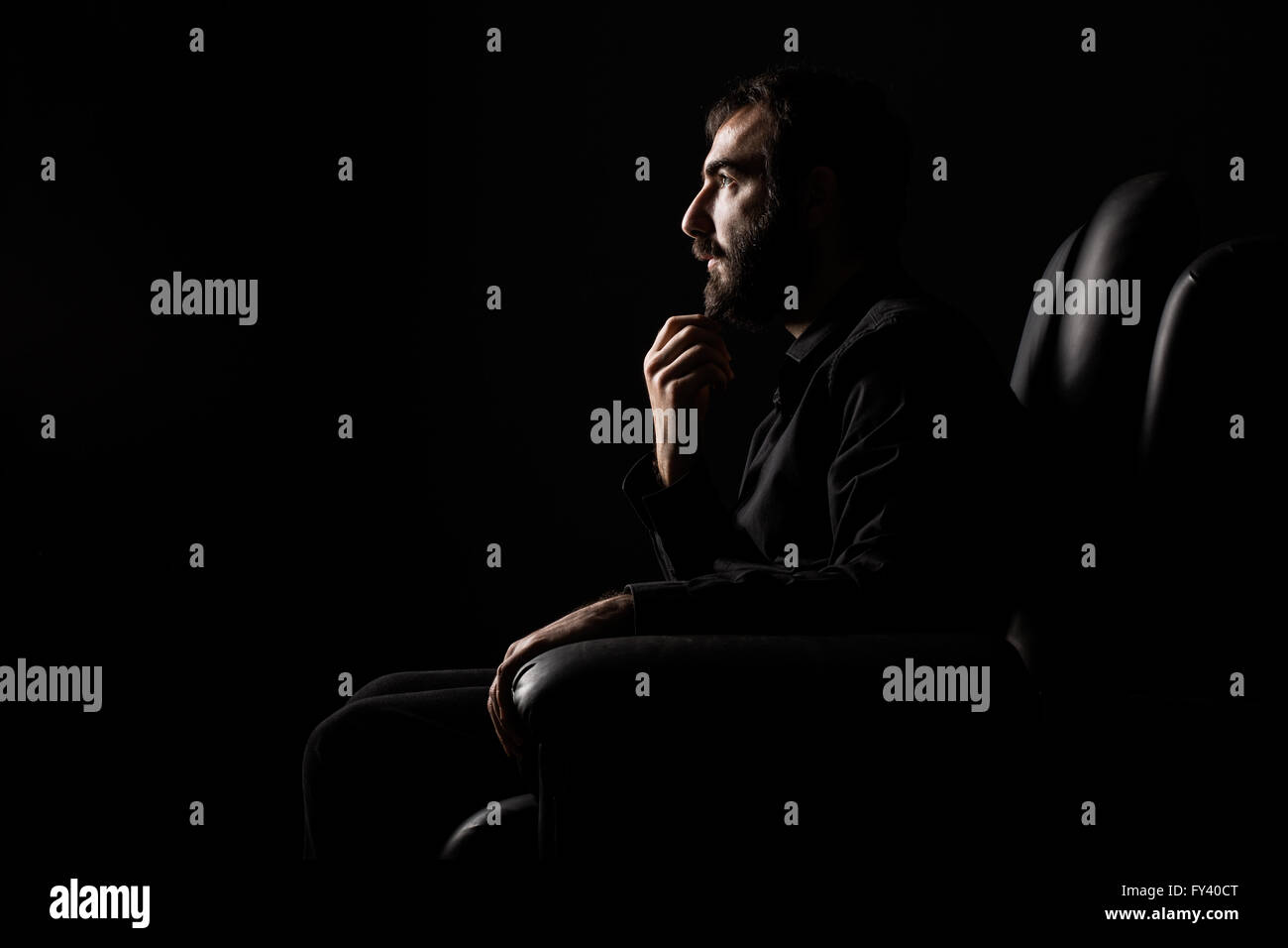Thinking Man with Beard Sittin on an Armchair Stock Photo - Alamy