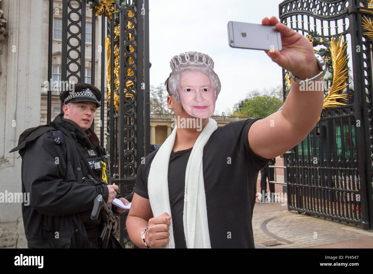 London UK.21th April 2016. A man wearing a face mask of The Queen poses ...