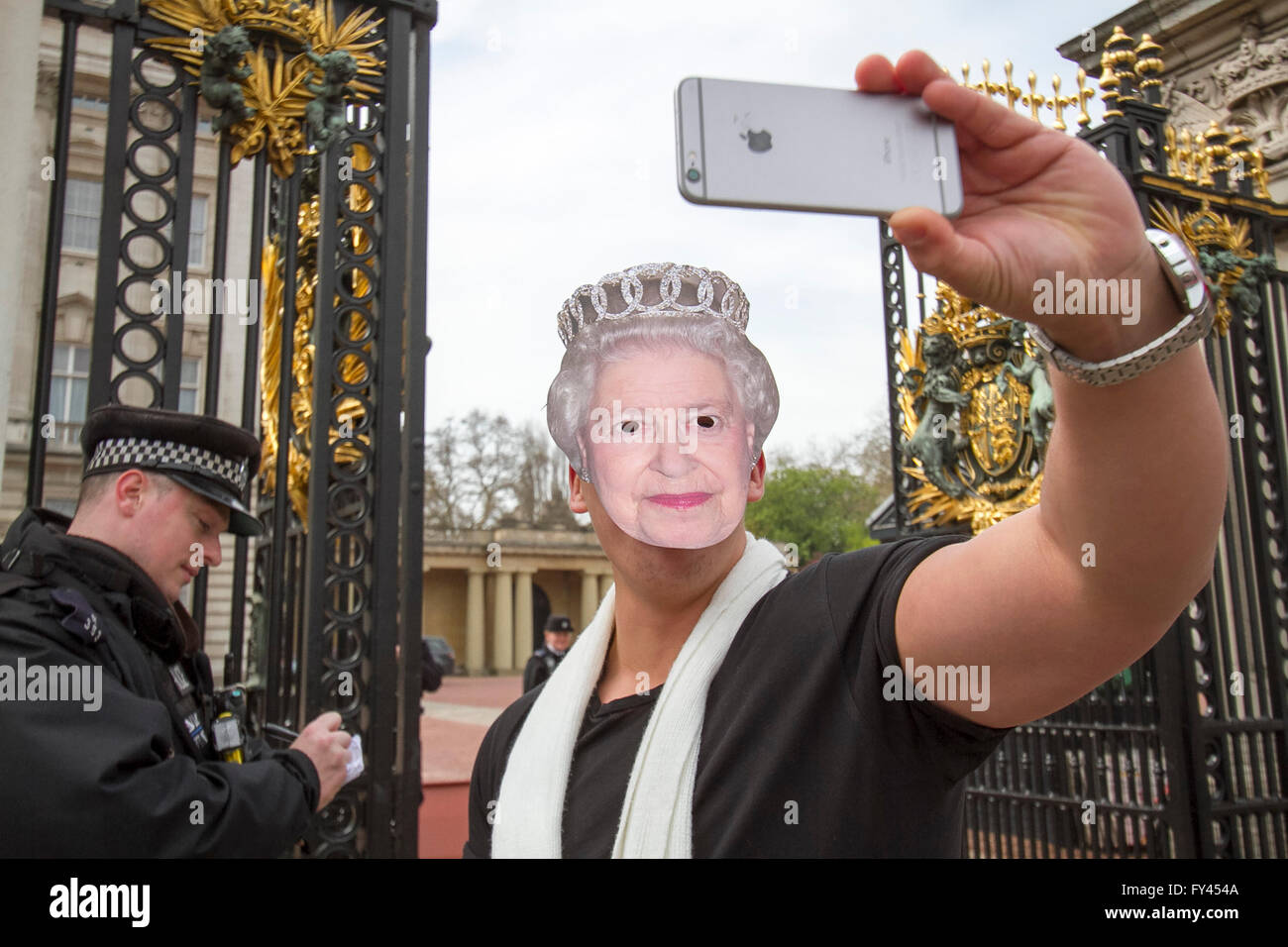 London UK.21th April 2016. A man wearing a face mask of The Queen poses ...