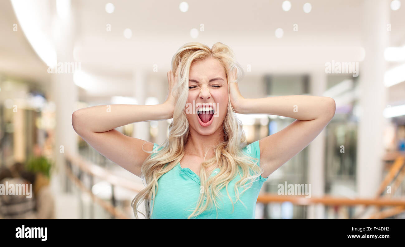 young woman holding to her head and screaming Stock Photo - Alamy