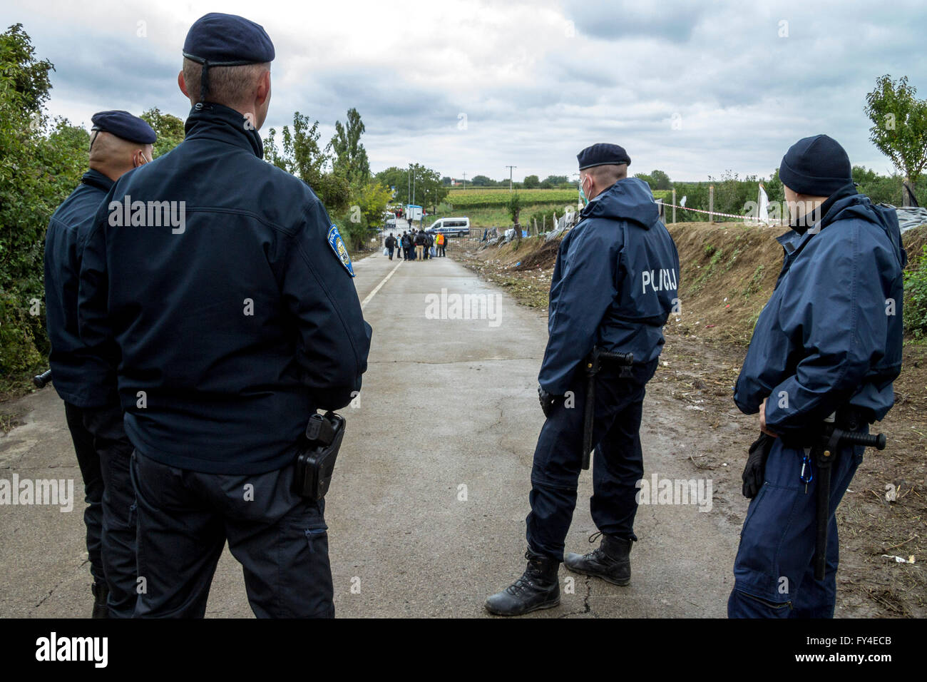 Croatian Policemen Watching Refugees Crossing The Serbo Croatian Border