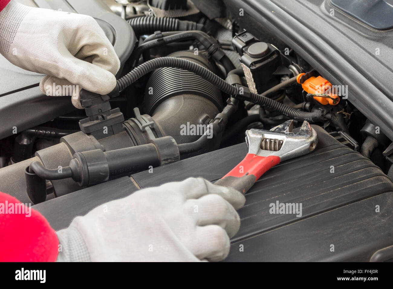 Mechanician performing maintenance on a car engine Stock Photo - Alamy