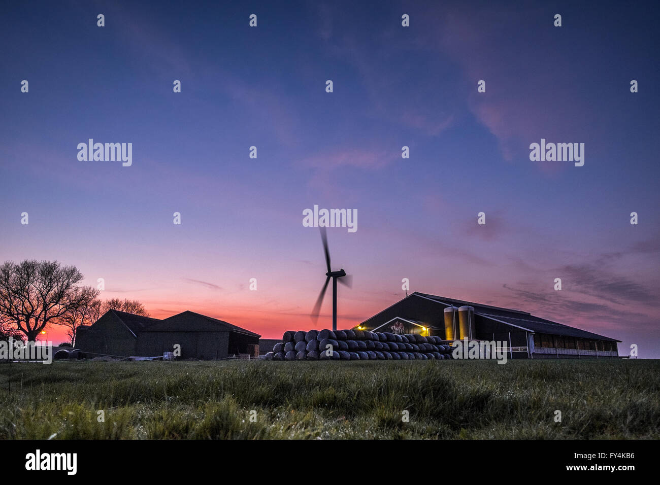 A wind powered farm in Friesland is bathed in the red orange glow of ...