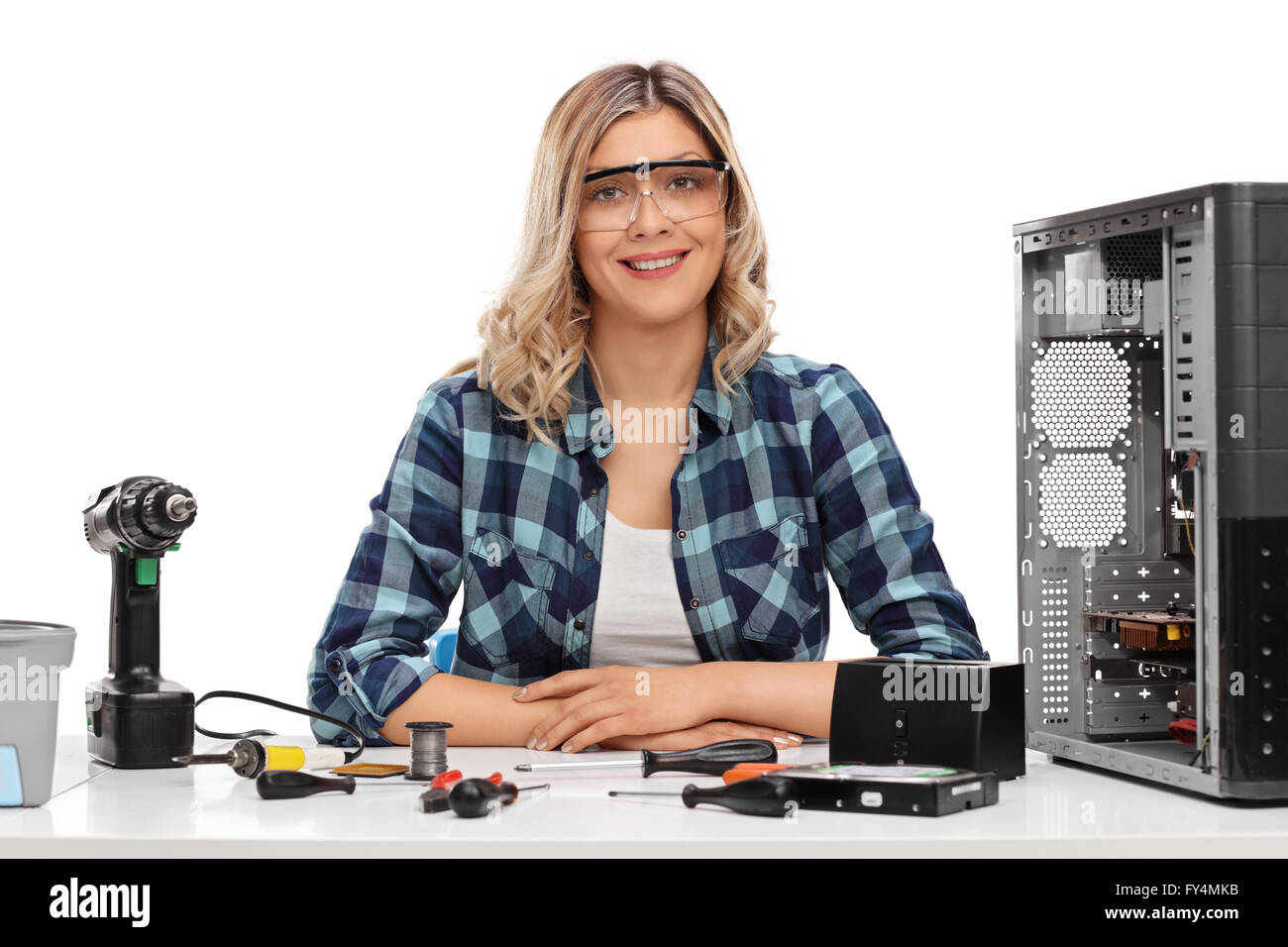 Female PC technician posing seated at a table with a bunch of tools on ...