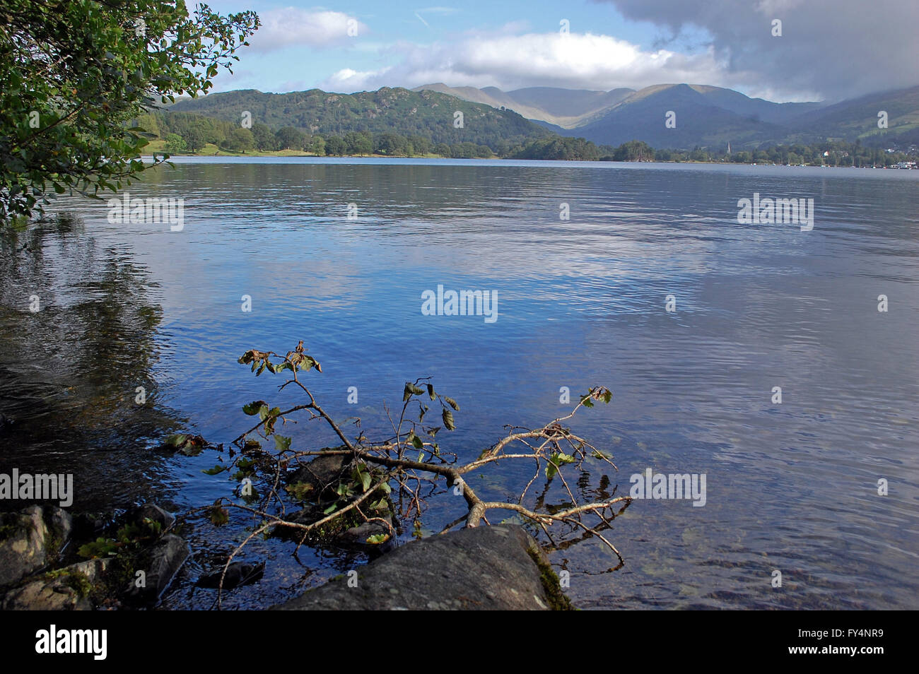 The still waters of Lake Windermere reflect the sky above with ...