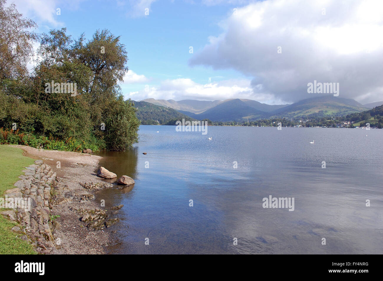 The still waters of Lake Windermere reflect the sky above with ...