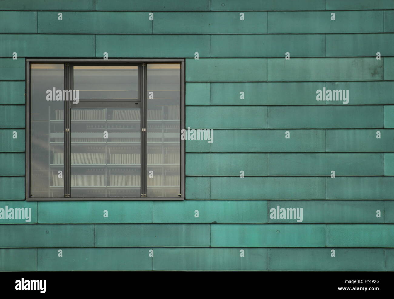 Rows of green metal panels and a window showing the inside of the ...