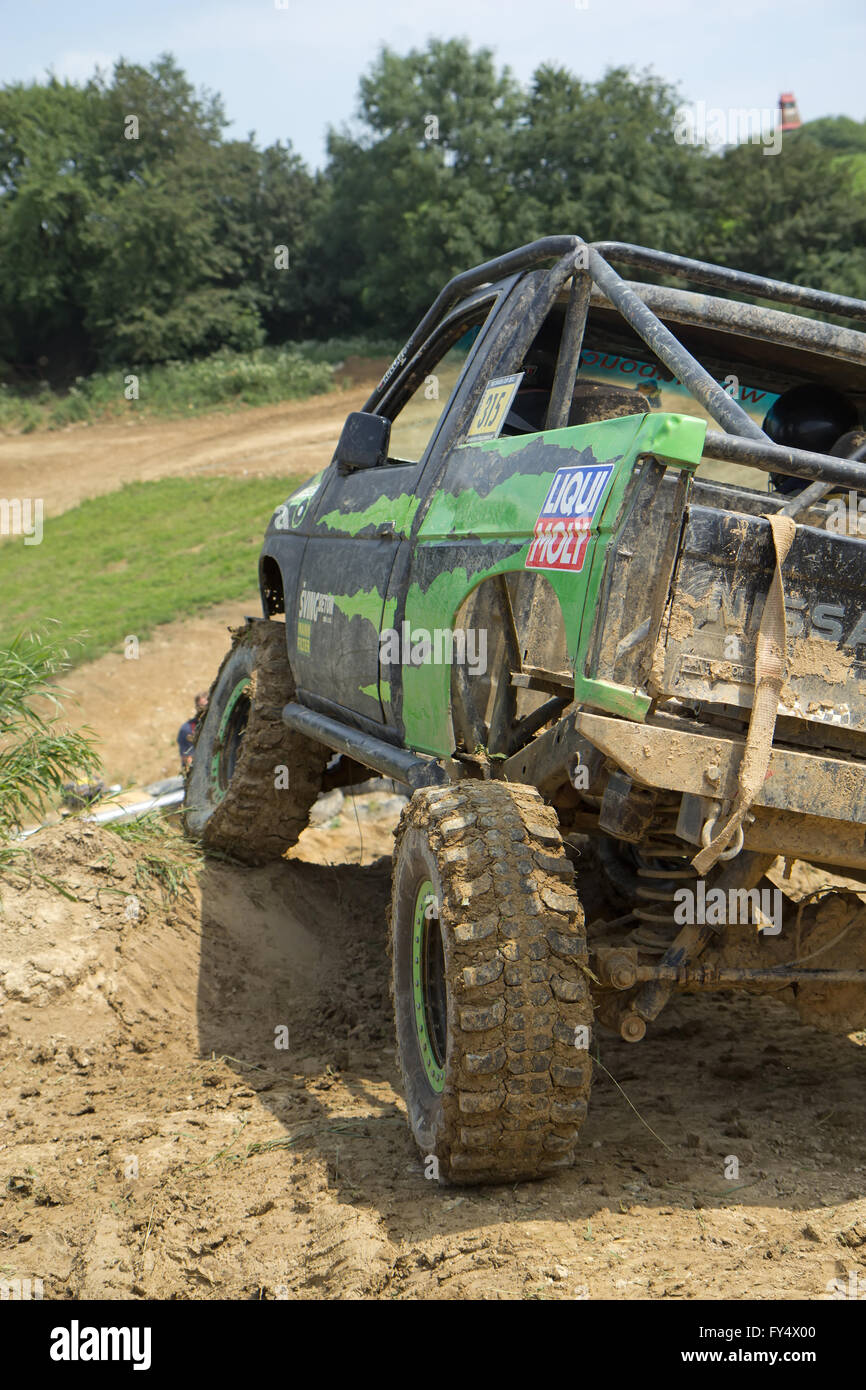 Green off-road car on a steep slope in the race Stock Photo - Alamy