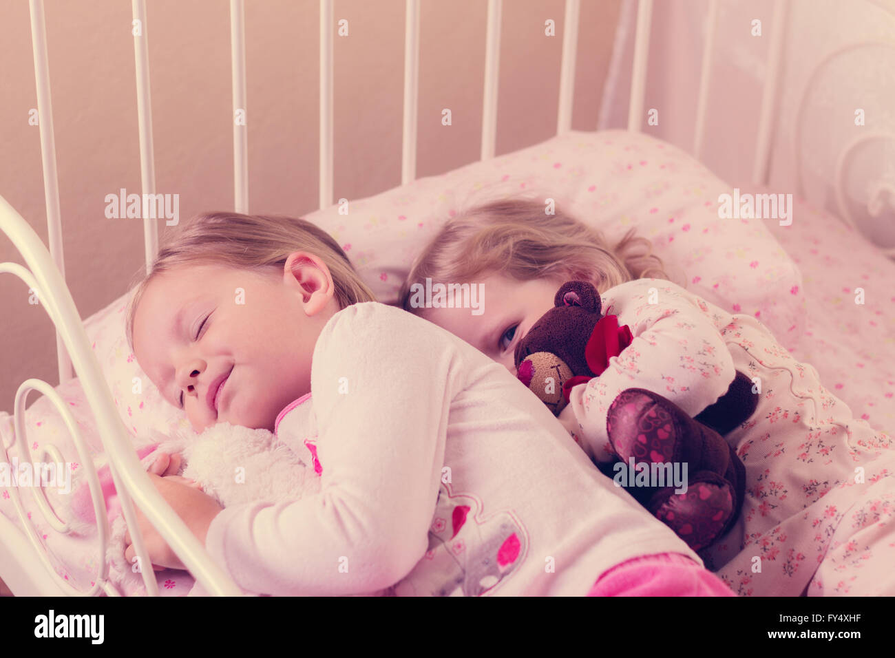 Little cute girls (sisters) fall asleep. Selective focus Stock Photo ...