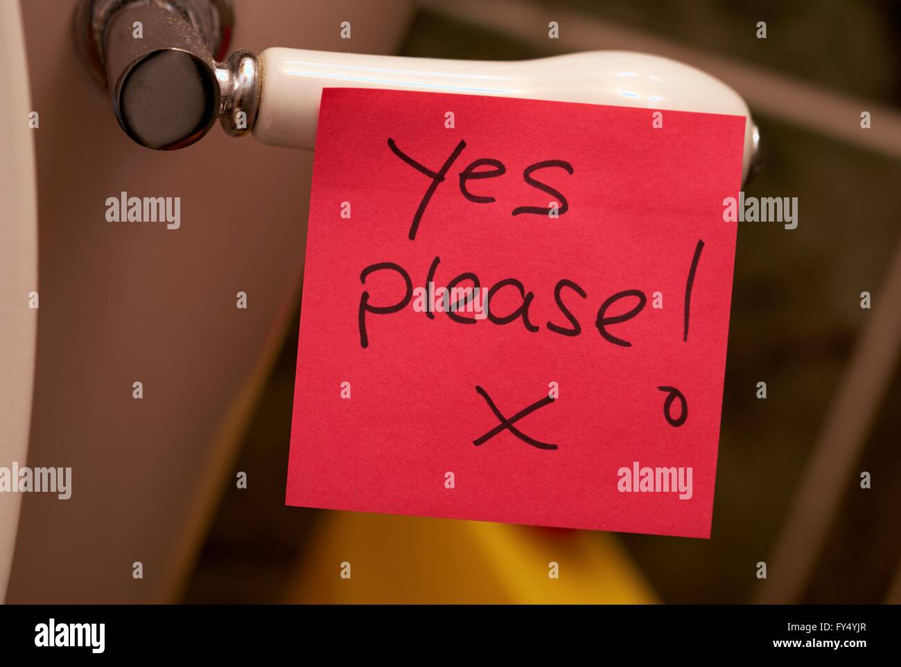 A post it note on a toilet handle with a hand written message yes ...