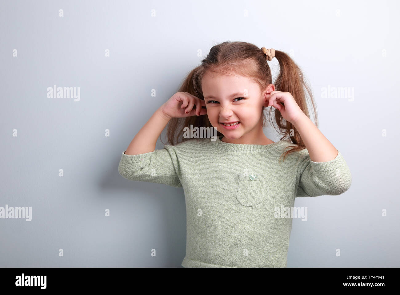Cute fun kid girl covered ears the fingers and gesturing that not want ...