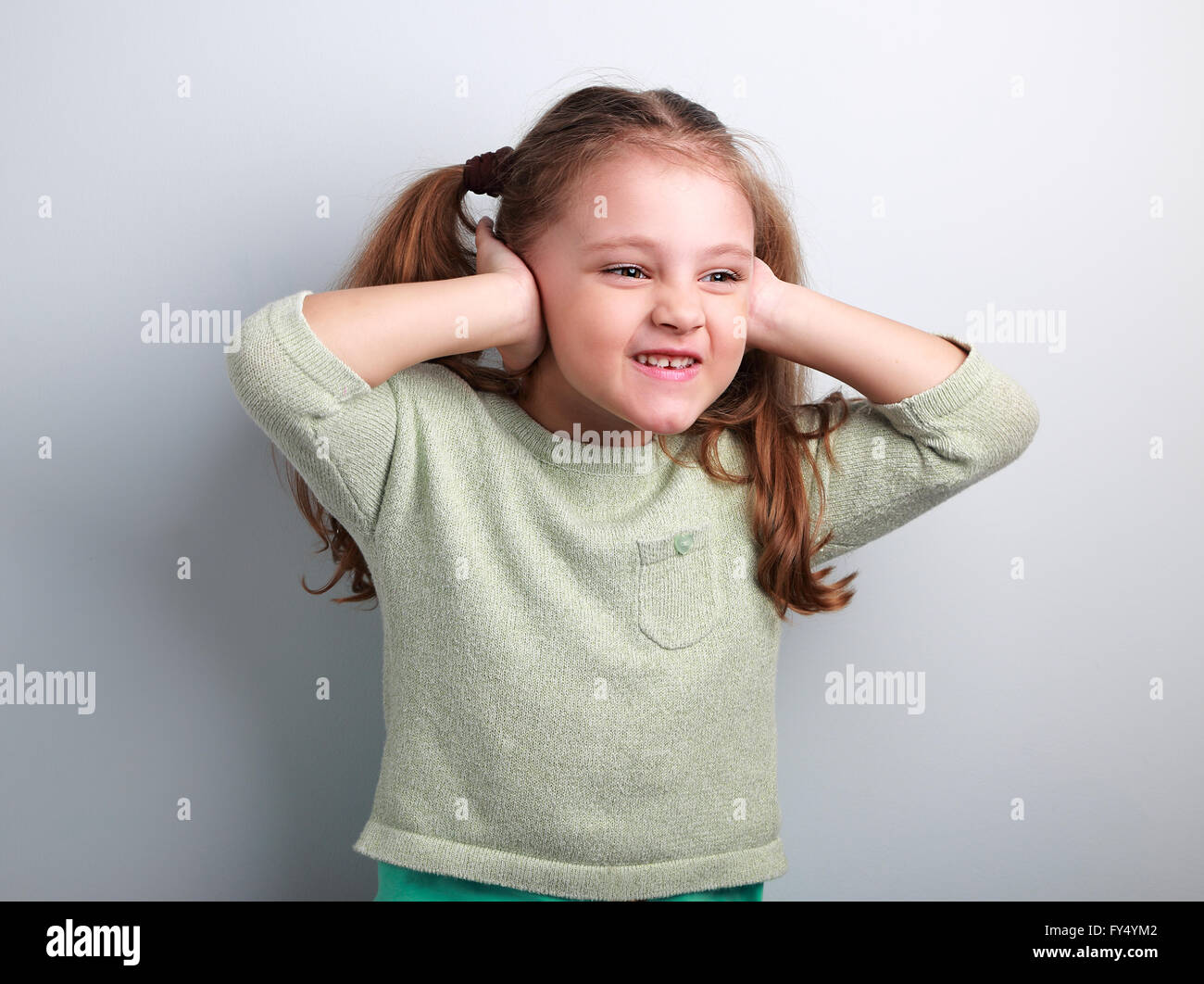 Cute fun kid girl covered ears the fingers and gesturing that not want ...