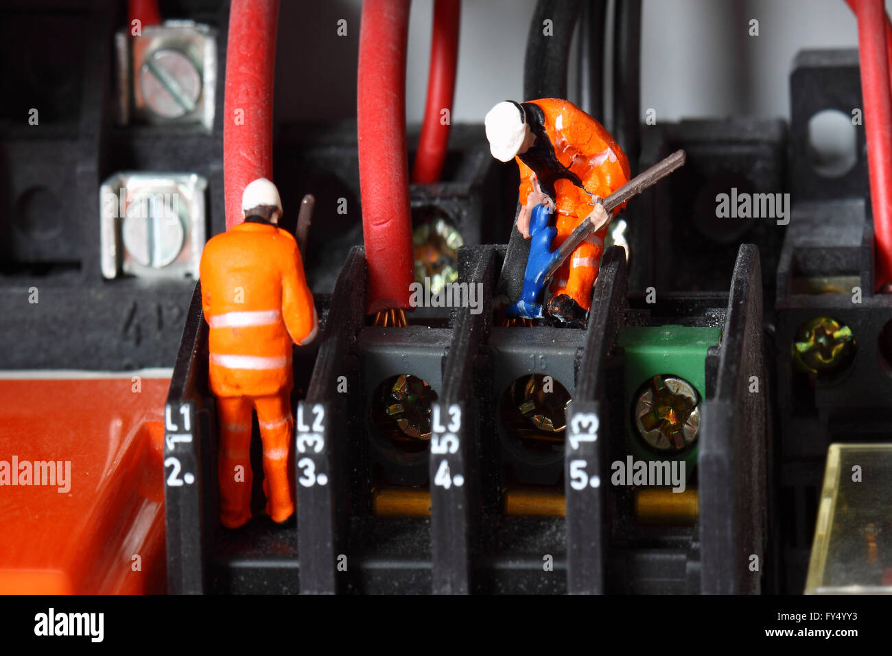 Miniature construction workers wiring electric circuit Stock Photo - Alamy
