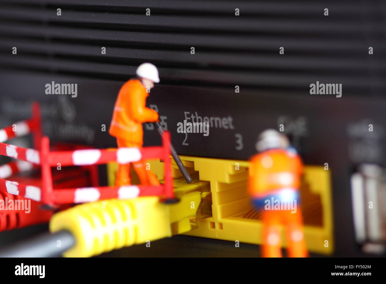 Miniature construction workers router connecting cable Stock Photo - Alamy