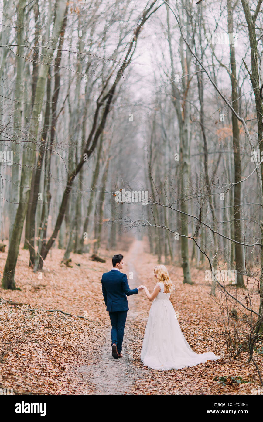 Happy wedding couple walking path hi-res stock photography and images ...