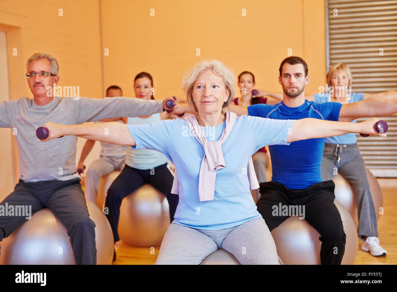 Group doing dumbbell exercises in gym for back training Stock Photo - Alamy