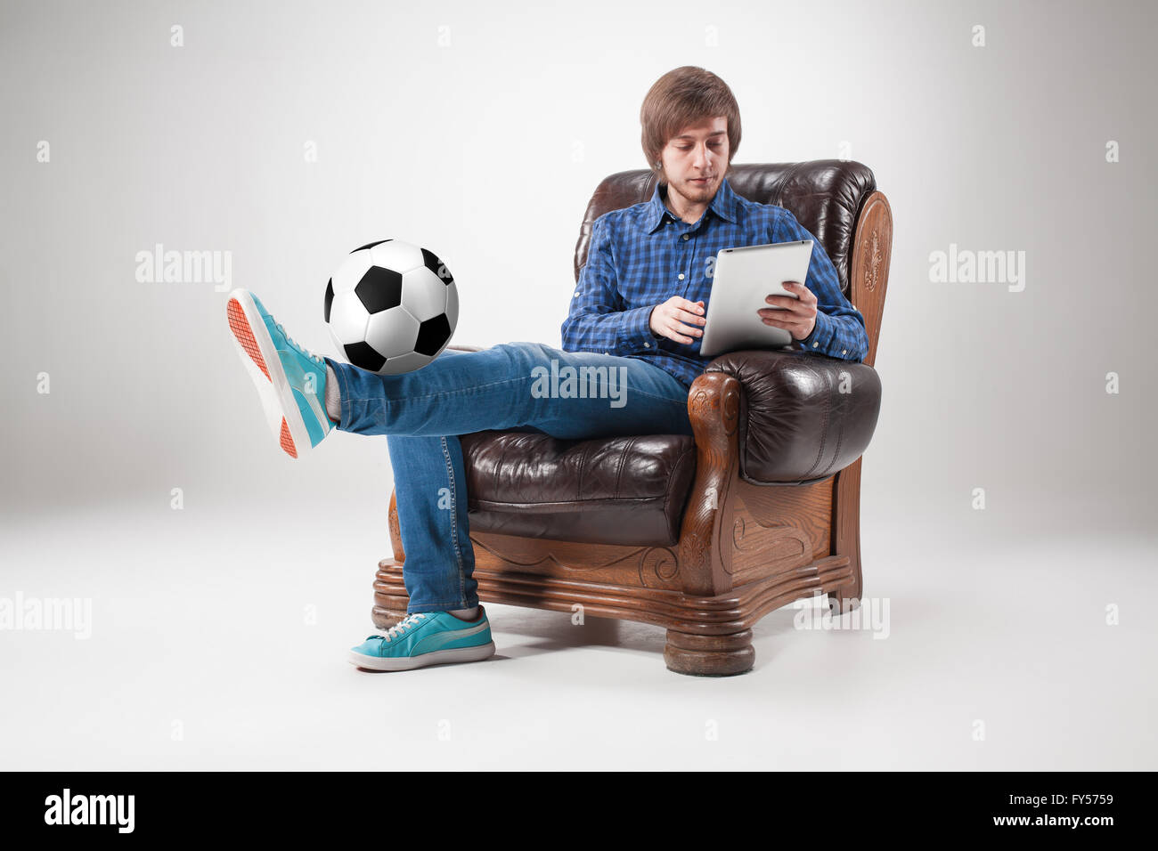 Portrait of young man with laptop and football ball Stock Photo - Alamy