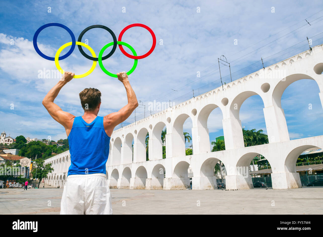 RIO DE JANEIRO - MARCH 29, 2016: Athlete holding Olympic rings stands ...
