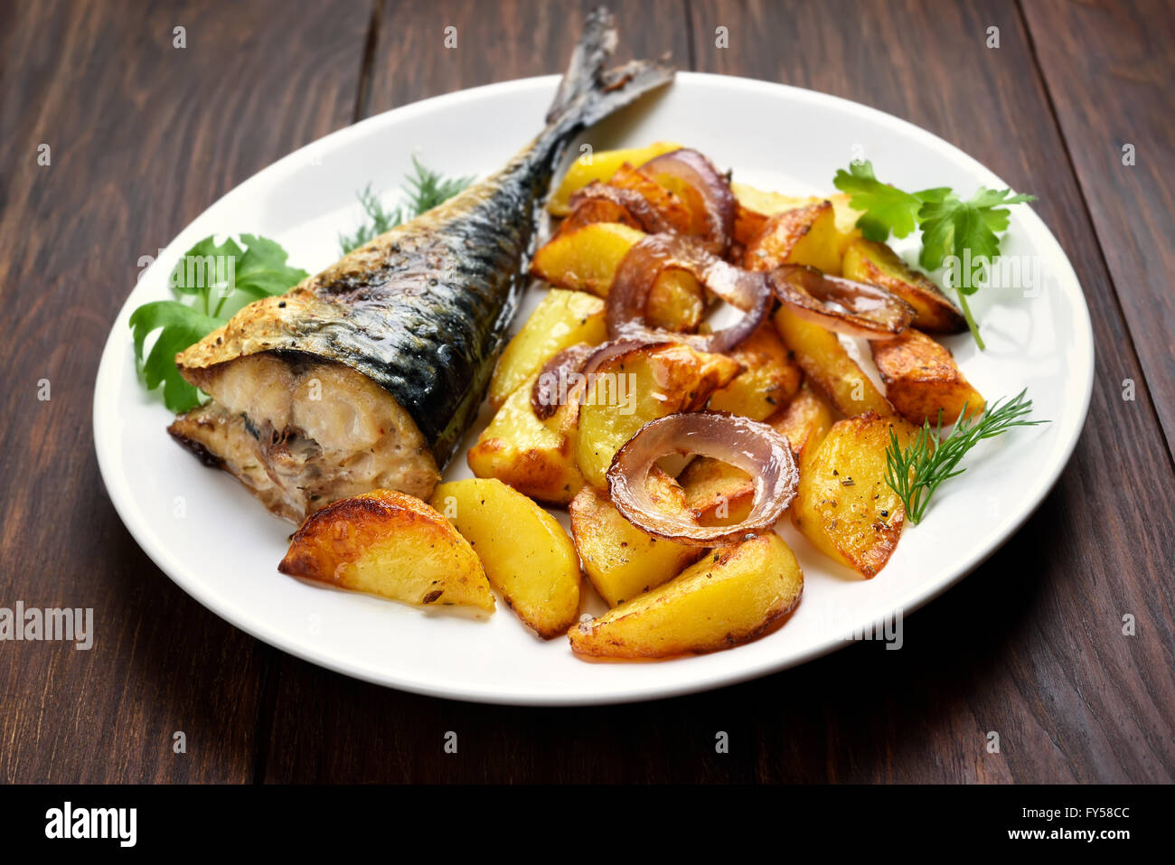 Baked potato wedges and mackerel fish on white plate Stock Photo - Alamy