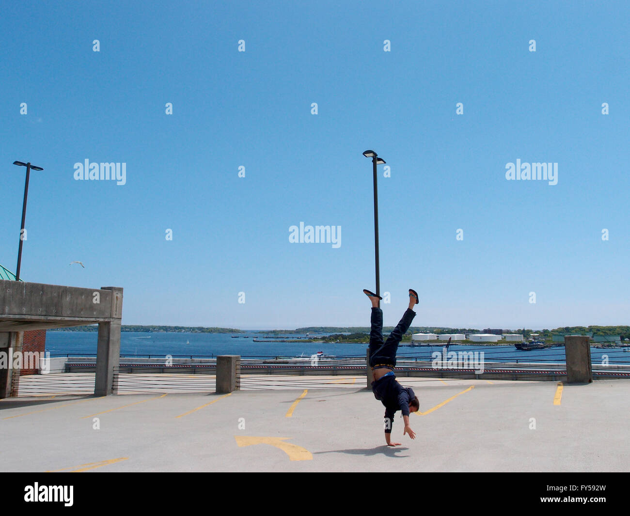 Man wearing a hoodie, pants, and slippers does one handed Handstands on ...