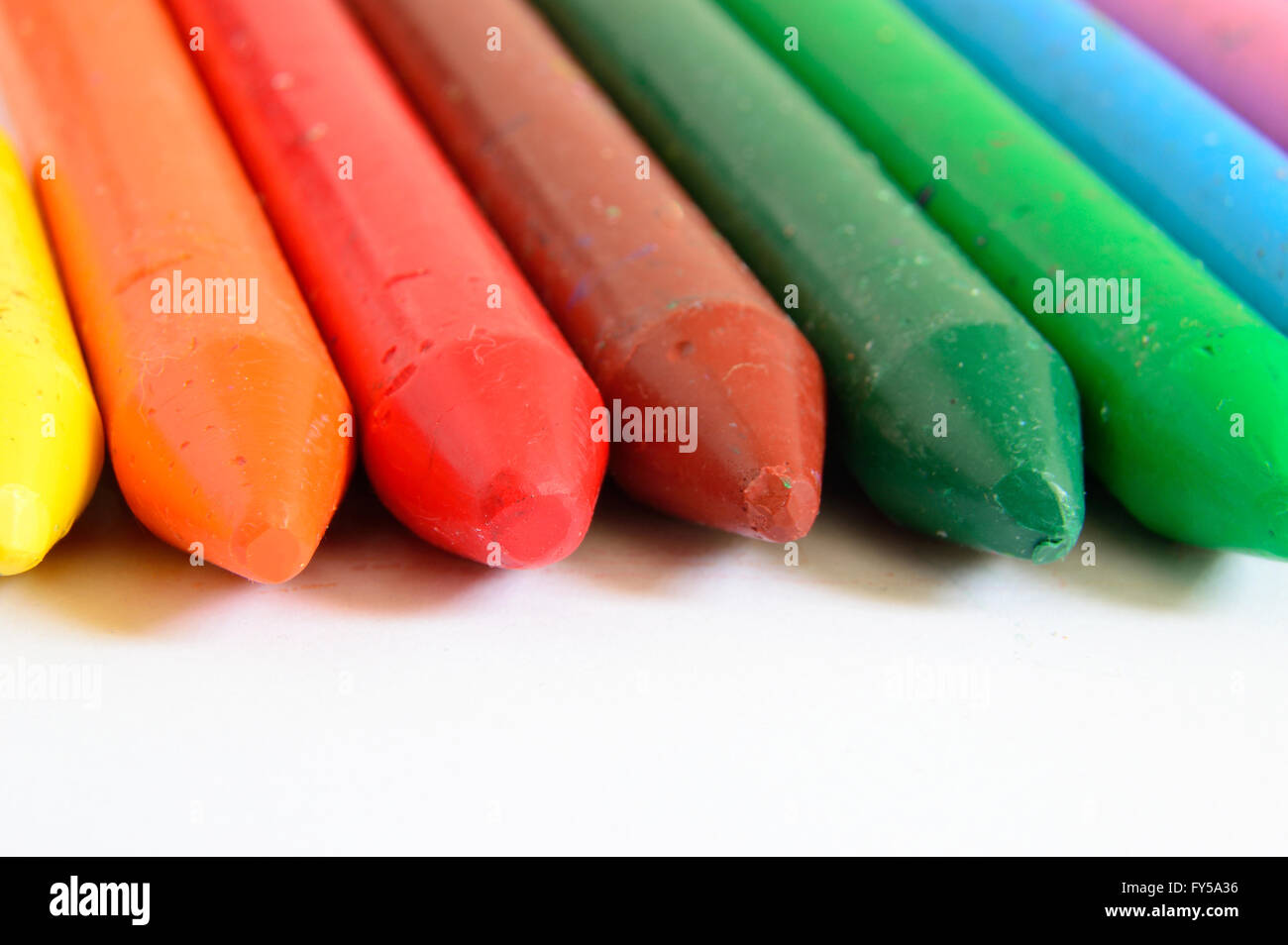 Macro of some colored wax crayons on a white background. Empty copy ...