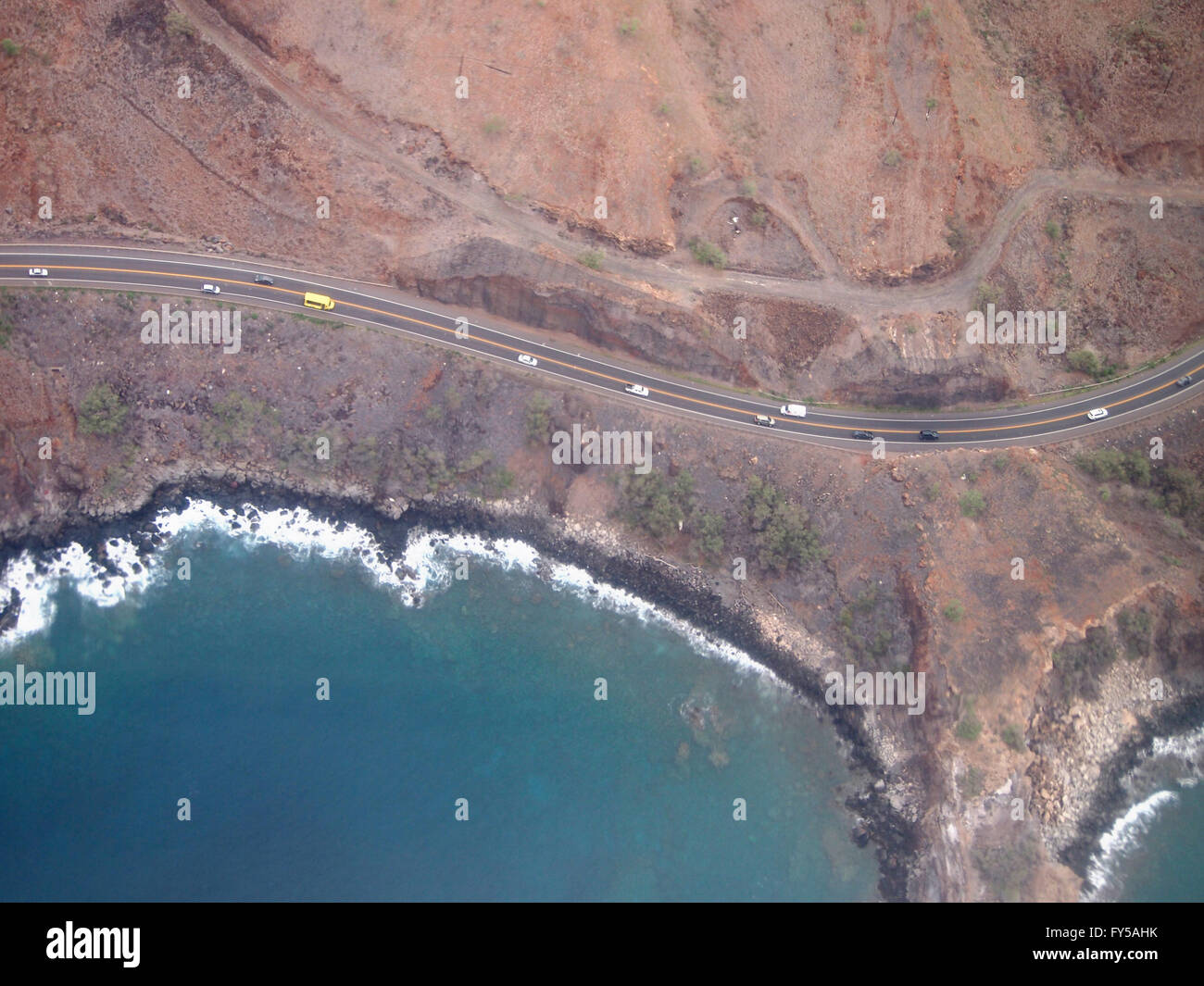 Aerial view of scenic road with cars driving along the coast of Maui ...