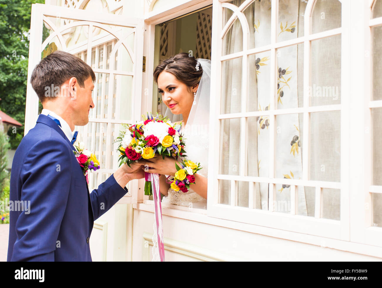 Handsome groom giving hand to beautiful bride Stock Photo - Alamy