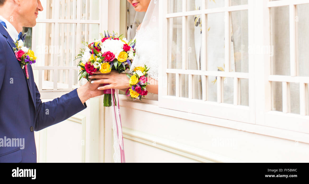 Handsome groom giving hand to beautiful bride Stock Photo - Alamy