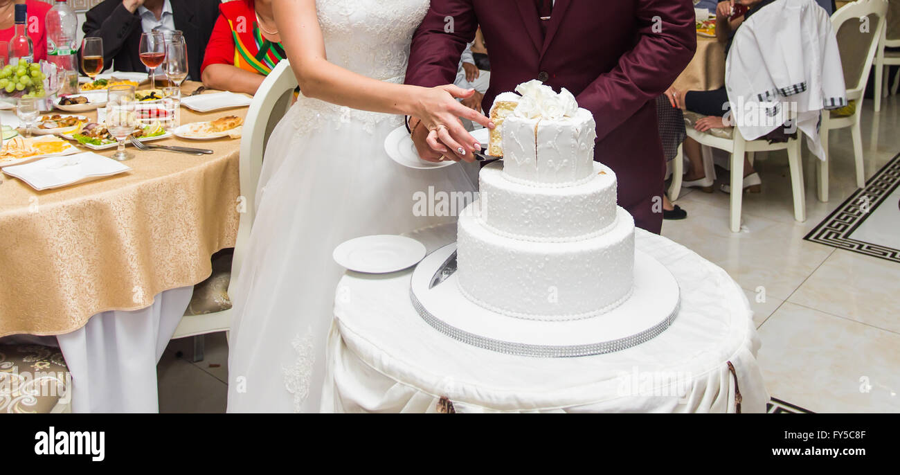 Bride and Groom at Wedding Reception Cutting the Cake Stock Photo - Alamy