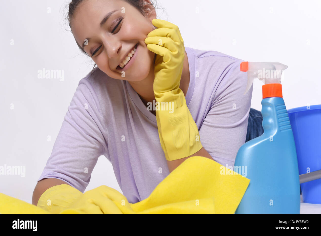 Close up to a happy young woman doing cleaning against white background ...
