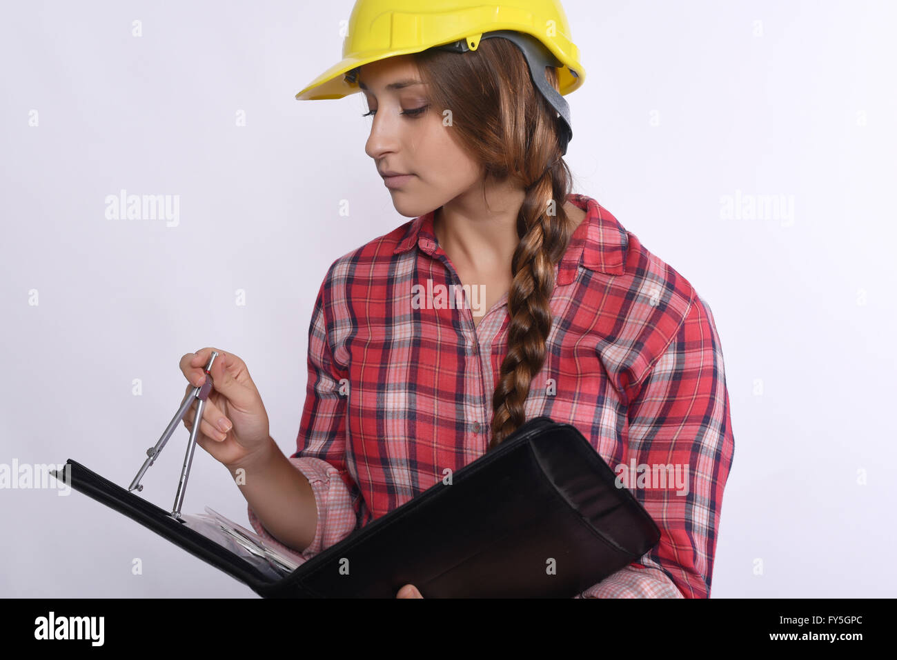 Portrait of beautiful woman construction worker reading blueprints ...