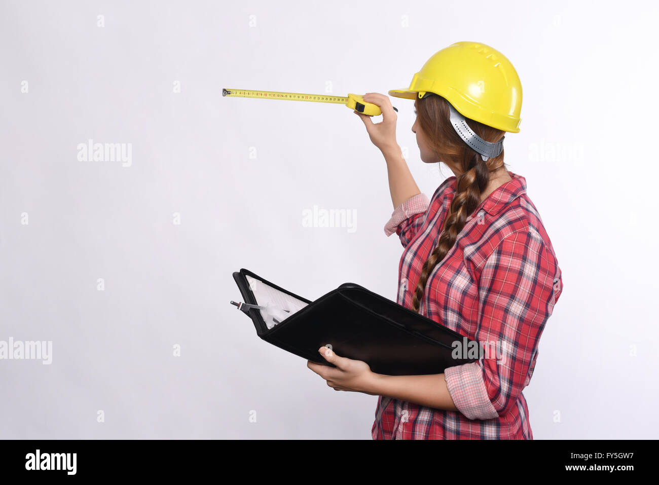 Portrait of beautiful woman construction worker taking measures with a ...