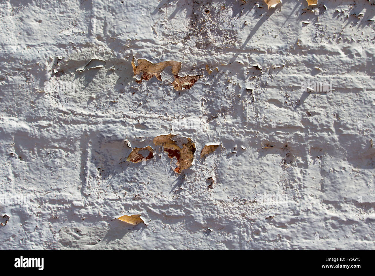 Weathered eroded peeling grey painted cement rendered clay brick wall ...