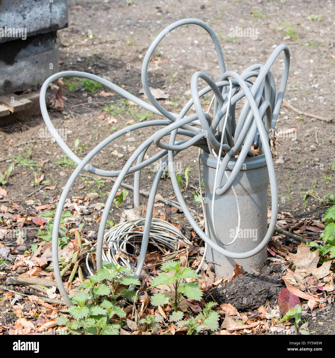 Pipe with cables coming out from the ground Stock Photo - Alamy