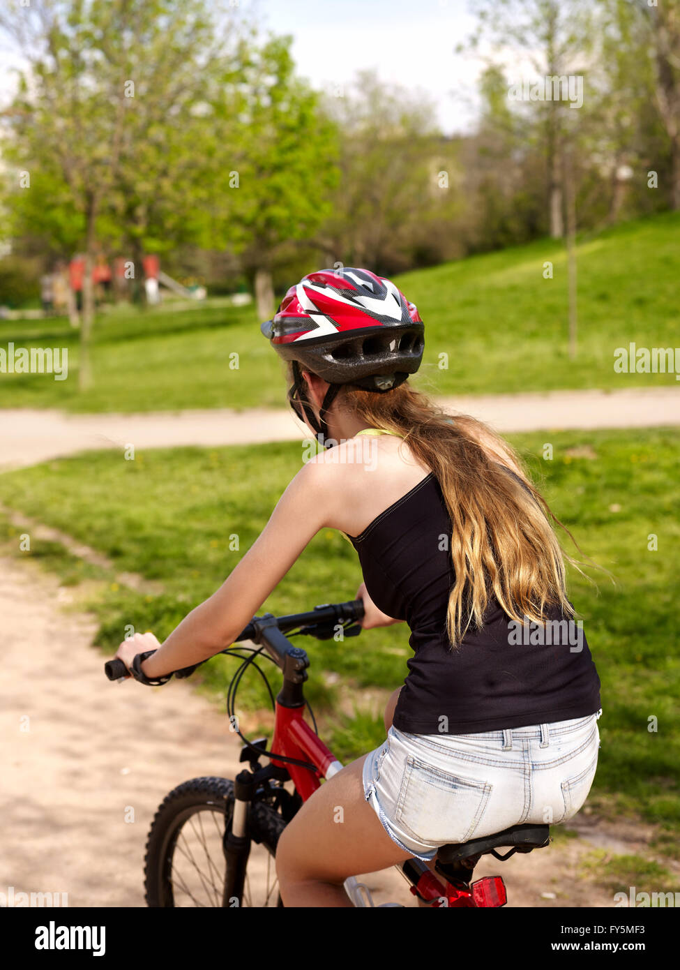 Bikes cycling girl wearing helmet ride on road into park Stock Photo ...
