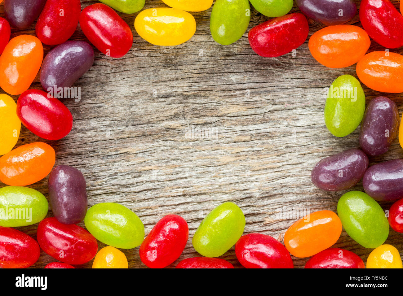 Wooden background with colorful candies frame. Copy-space Stock Photo ...