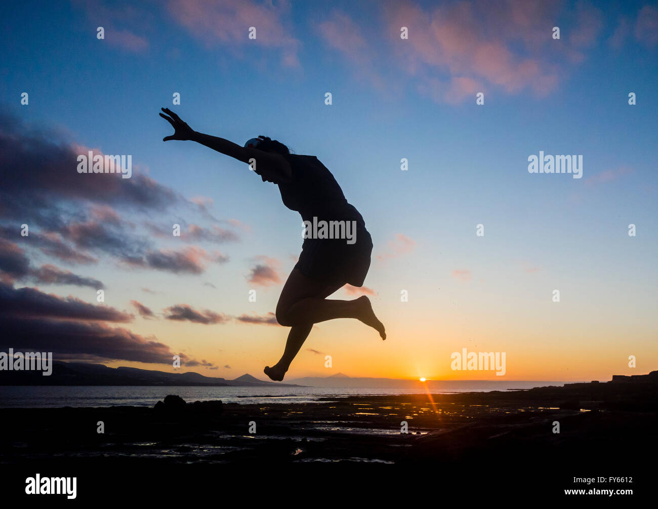 Woman jumping on beach at sunset Stock Photo - Alamy