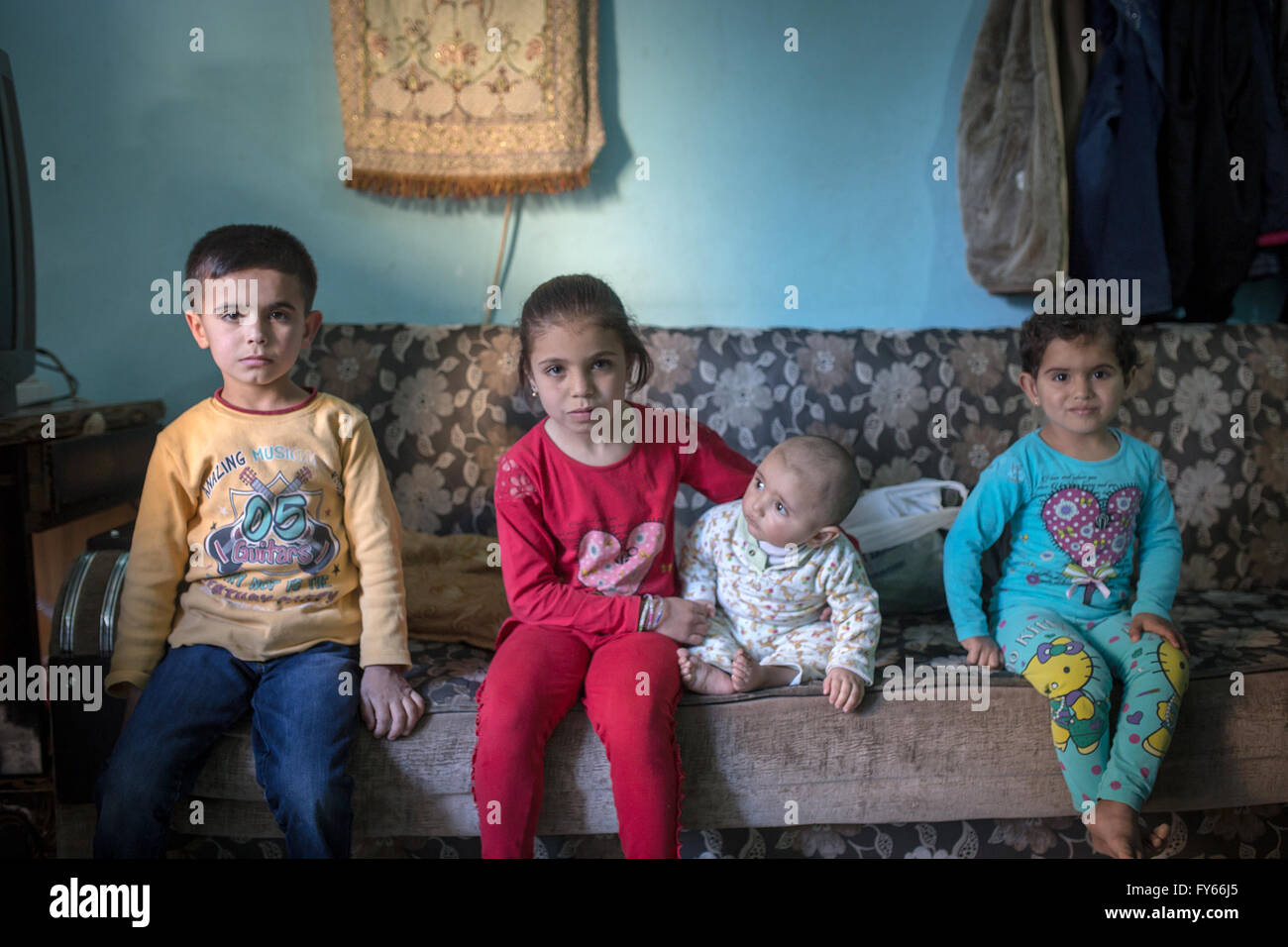 Kids of a syrian family are sitting on a couch in their place in ...