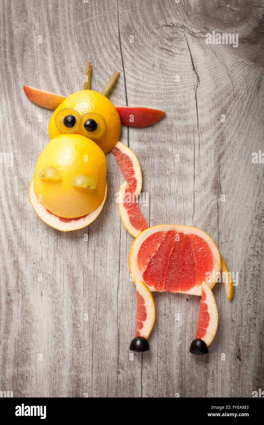 Smiling giraffe made of grapefruit on wooden background Stock Photo - Alamy