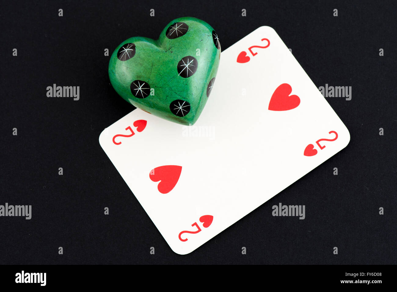 Playing card and stone love on black table Stock Photo - Alamy
