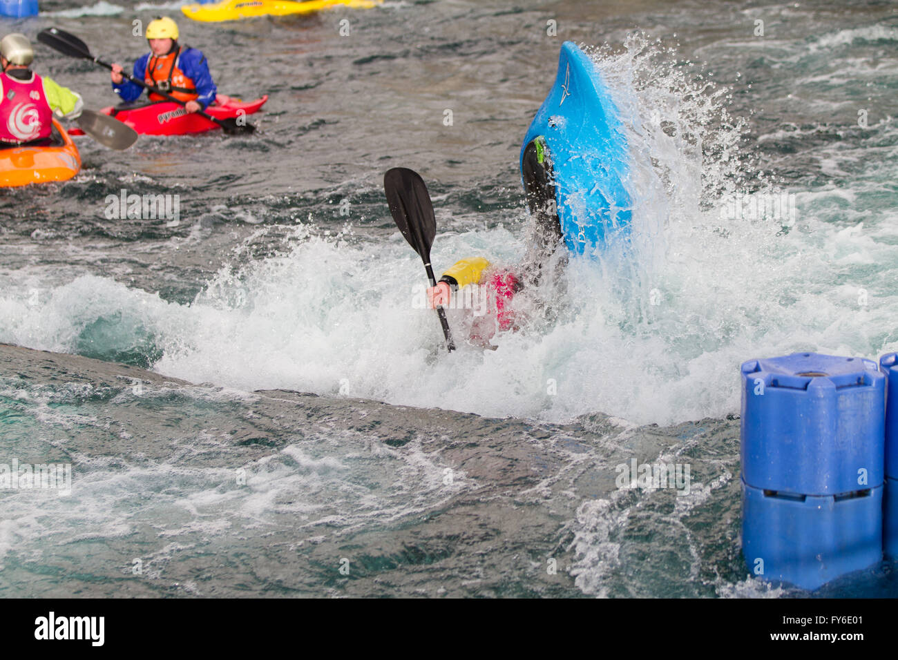 Young male man paddling a kayak in white water. The boat is mostly ...