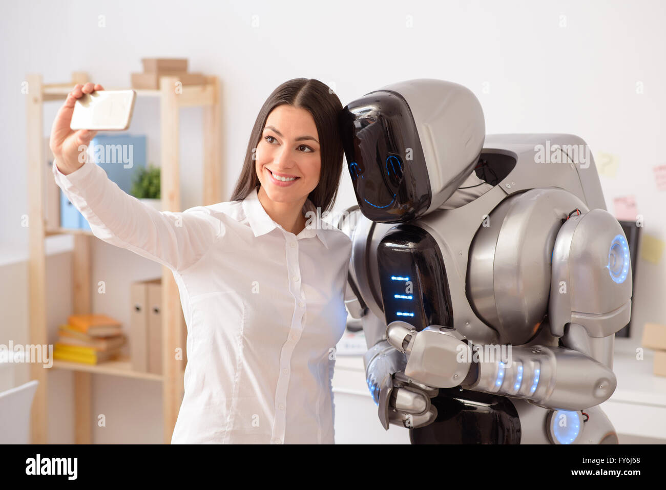 Positive girl making selfies with robot Stock Photo - Alamy